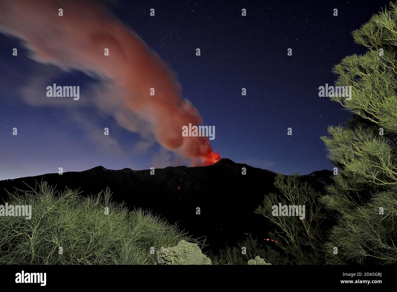 smoke from Etna Volcano during a eruption at night against starry sky ...