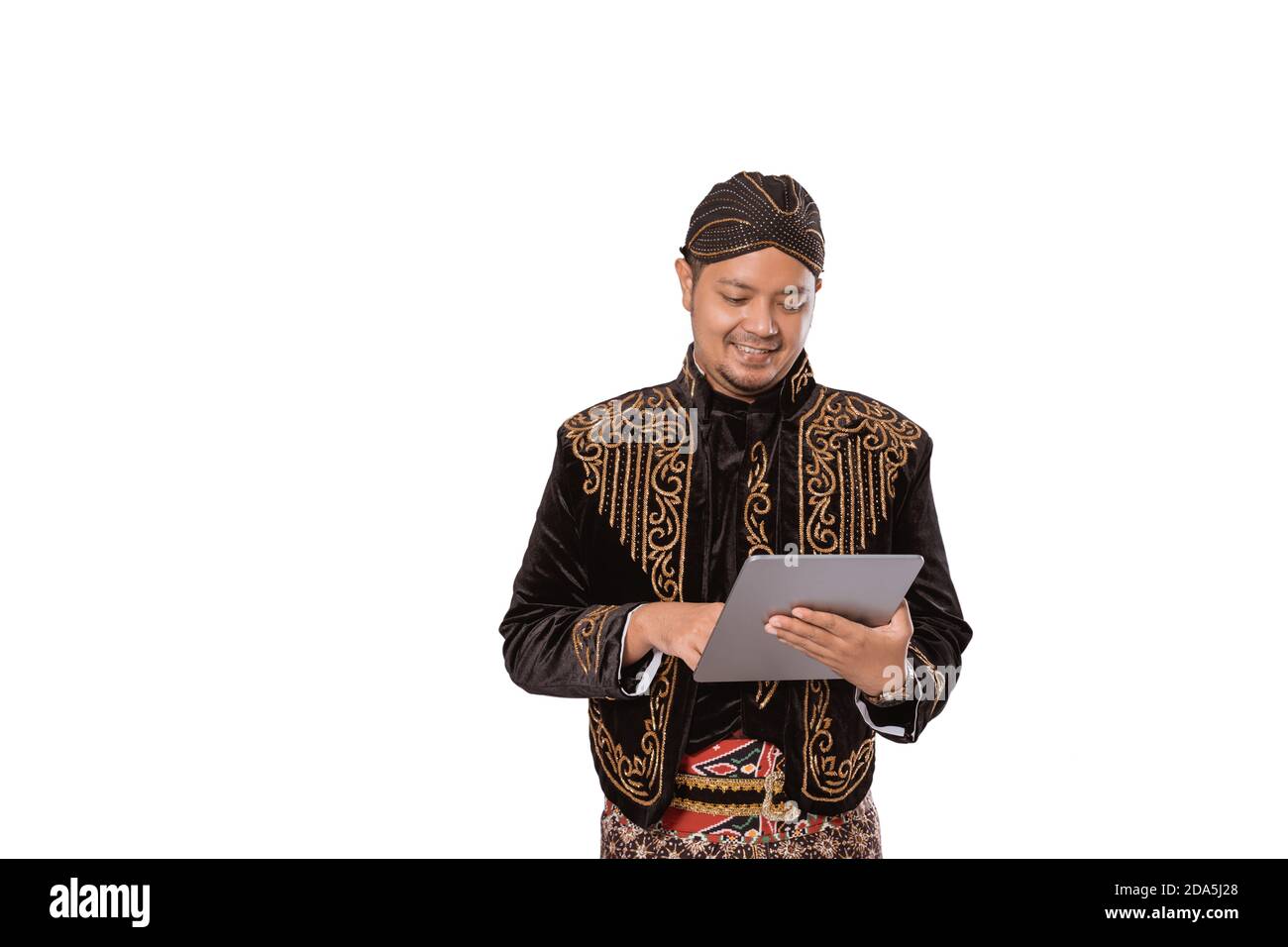 Portrait of a happy traditional Javanese man holding a tablet. Isolated ...