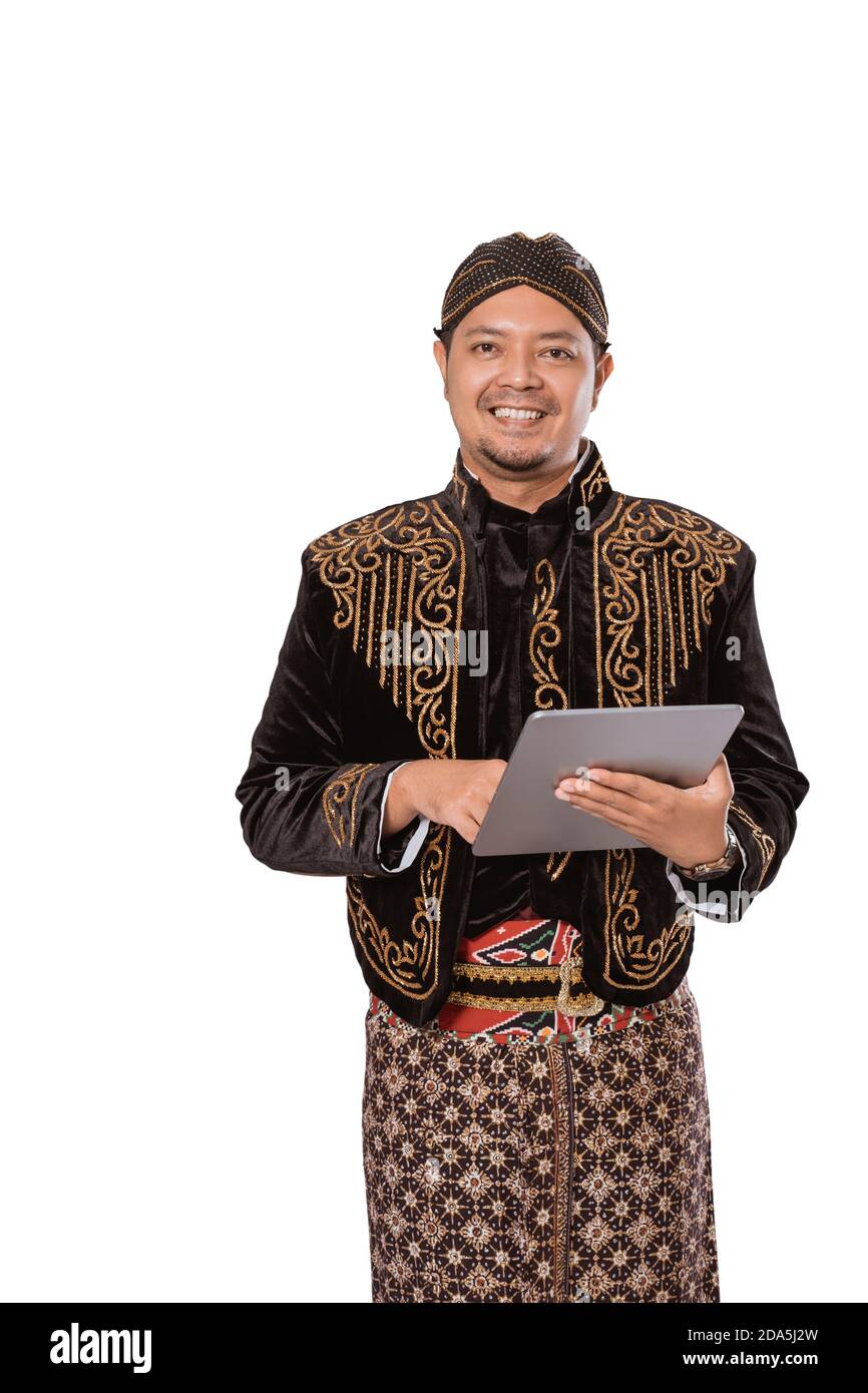 Portrait of a happy traditional Javanese man holding a tablet. Isolated ...