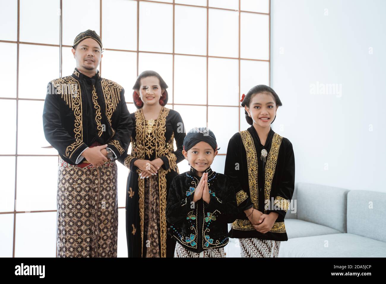 Portrait of a happy family wearing traditional Javanese clothes ...