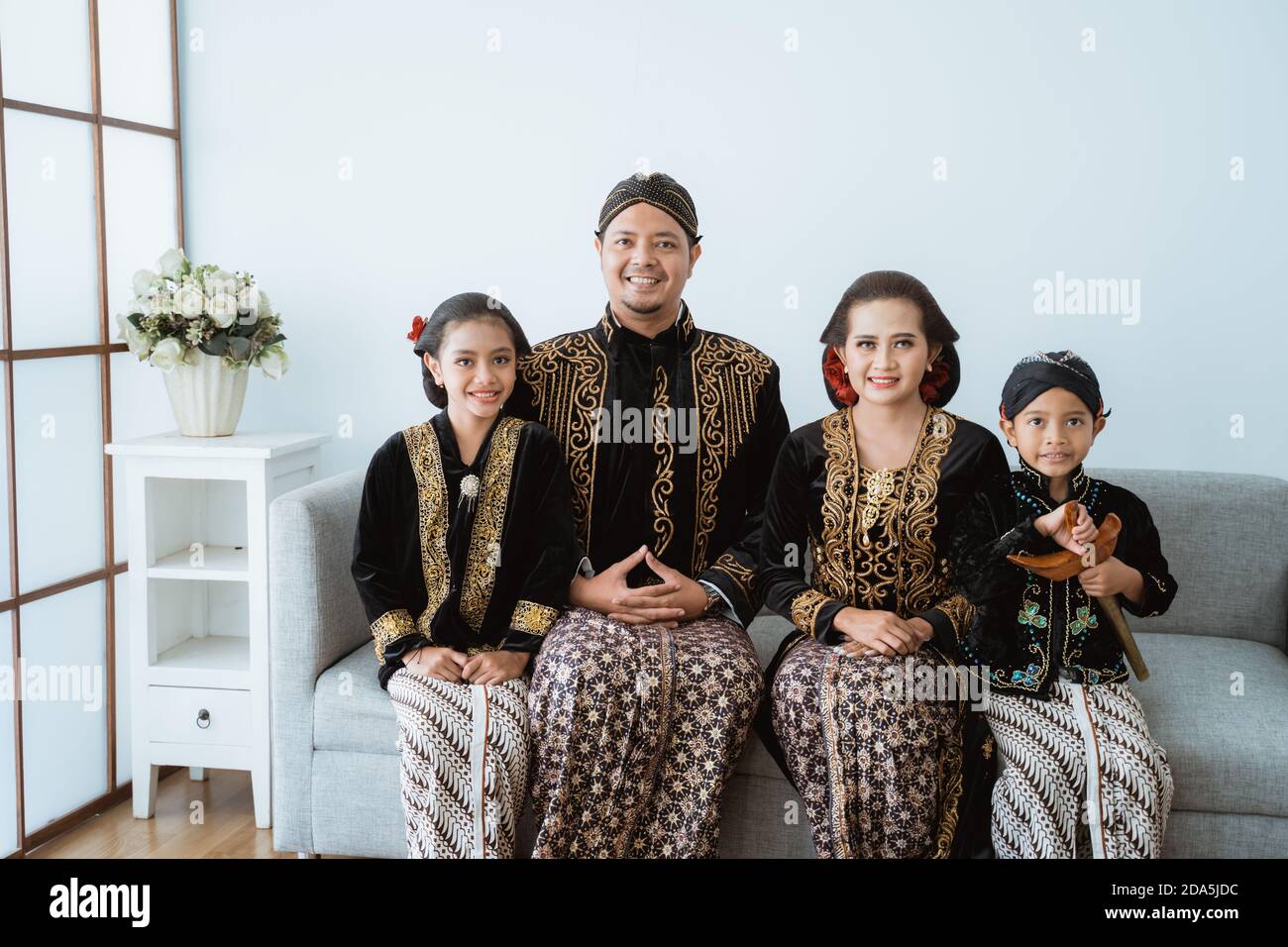 Portrait of a happy family wearing traditional Javanese clothes ...