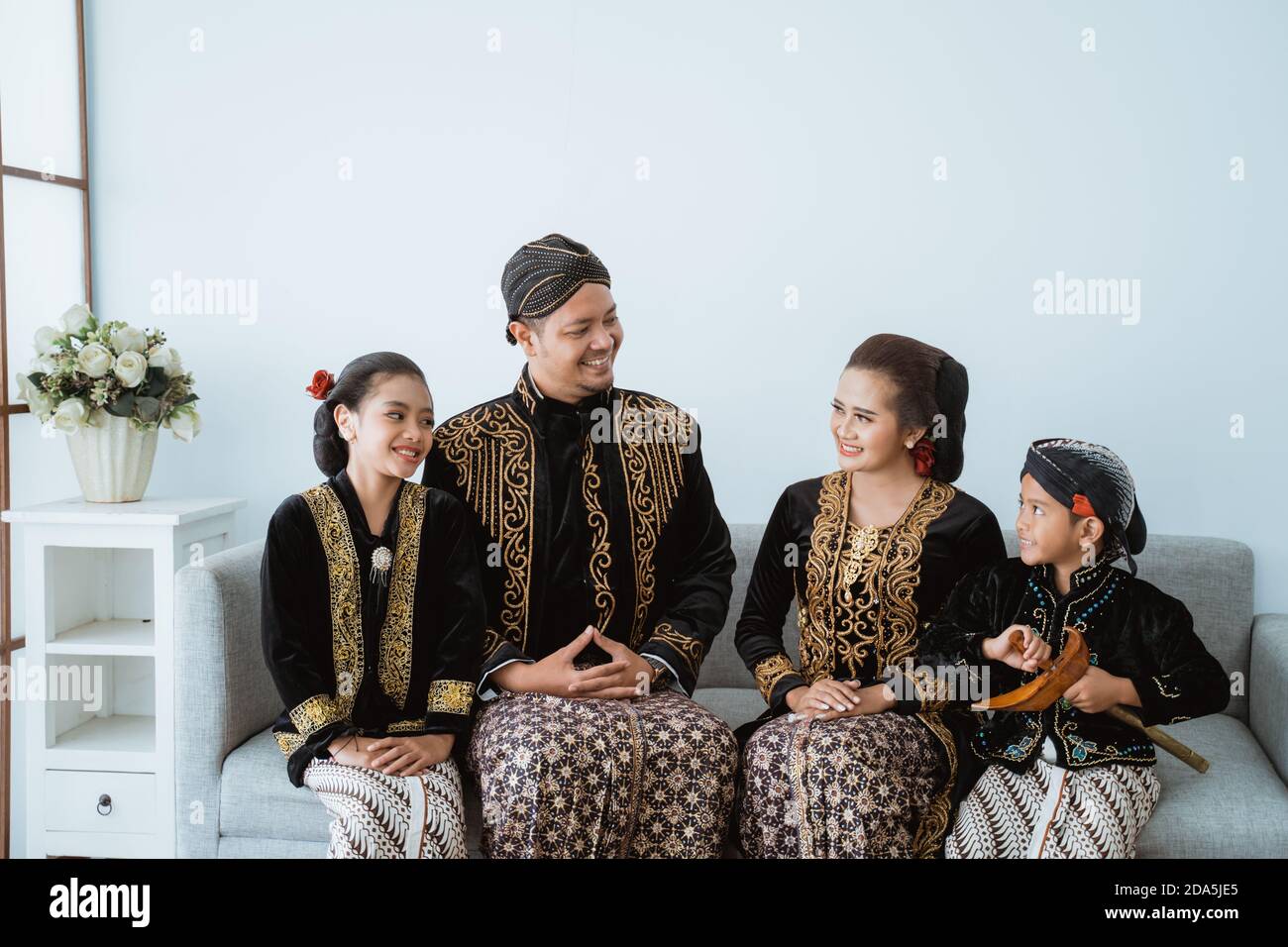 Portrait of a happy family wearing traditional Javanese clothes ...