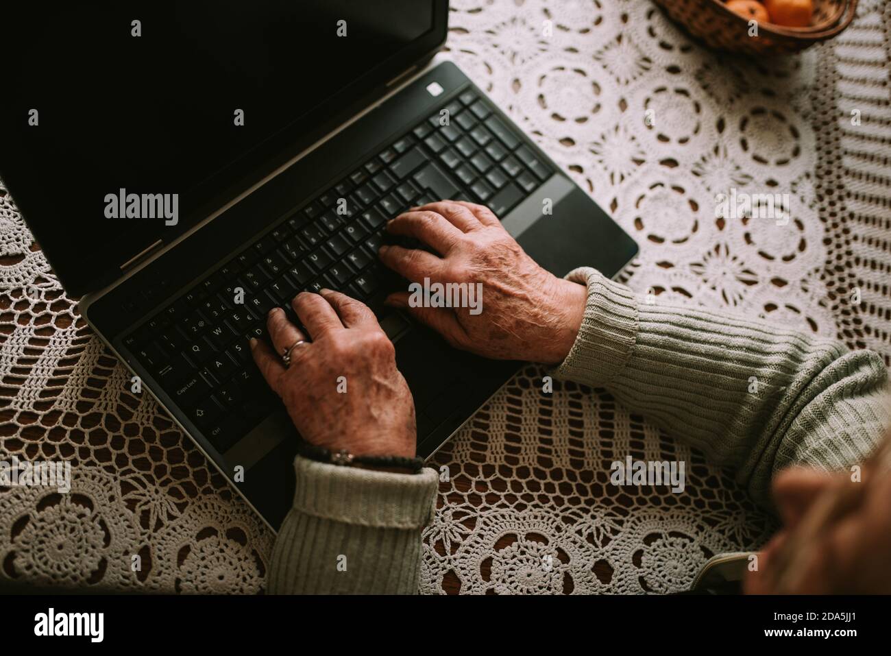Top view of senior grandmother's old hand typing messages on laptop ...
