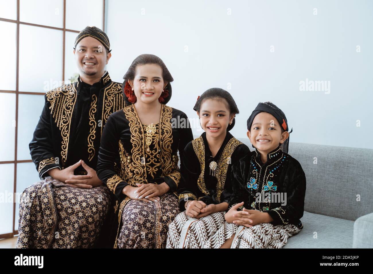 Portrait of a happy family wearing traditional Javanese clothes ...