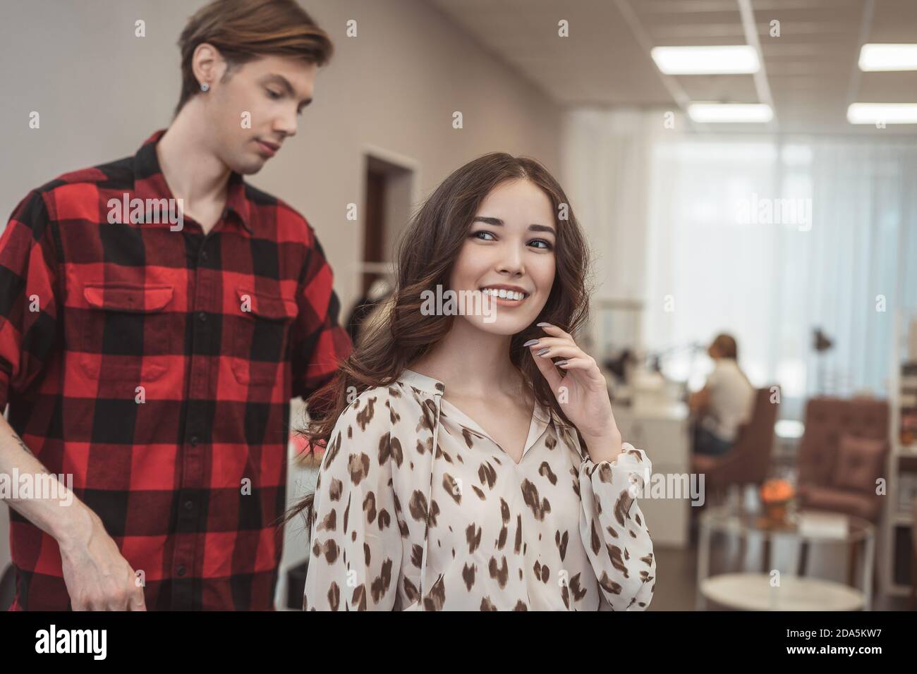 Stylist barber styling long hair for beautiful asian young woman in ...