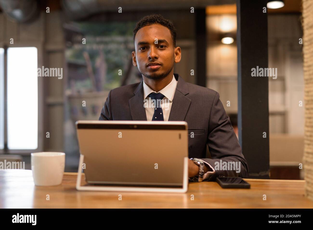 Young African businessman using laptop computer at coffee shop Stock ...