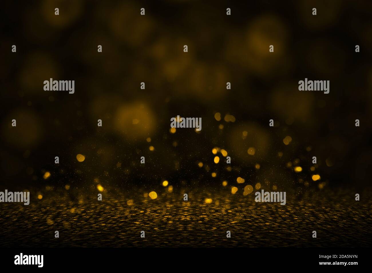Golden sprinkle on black background Stock Photo - Alamy