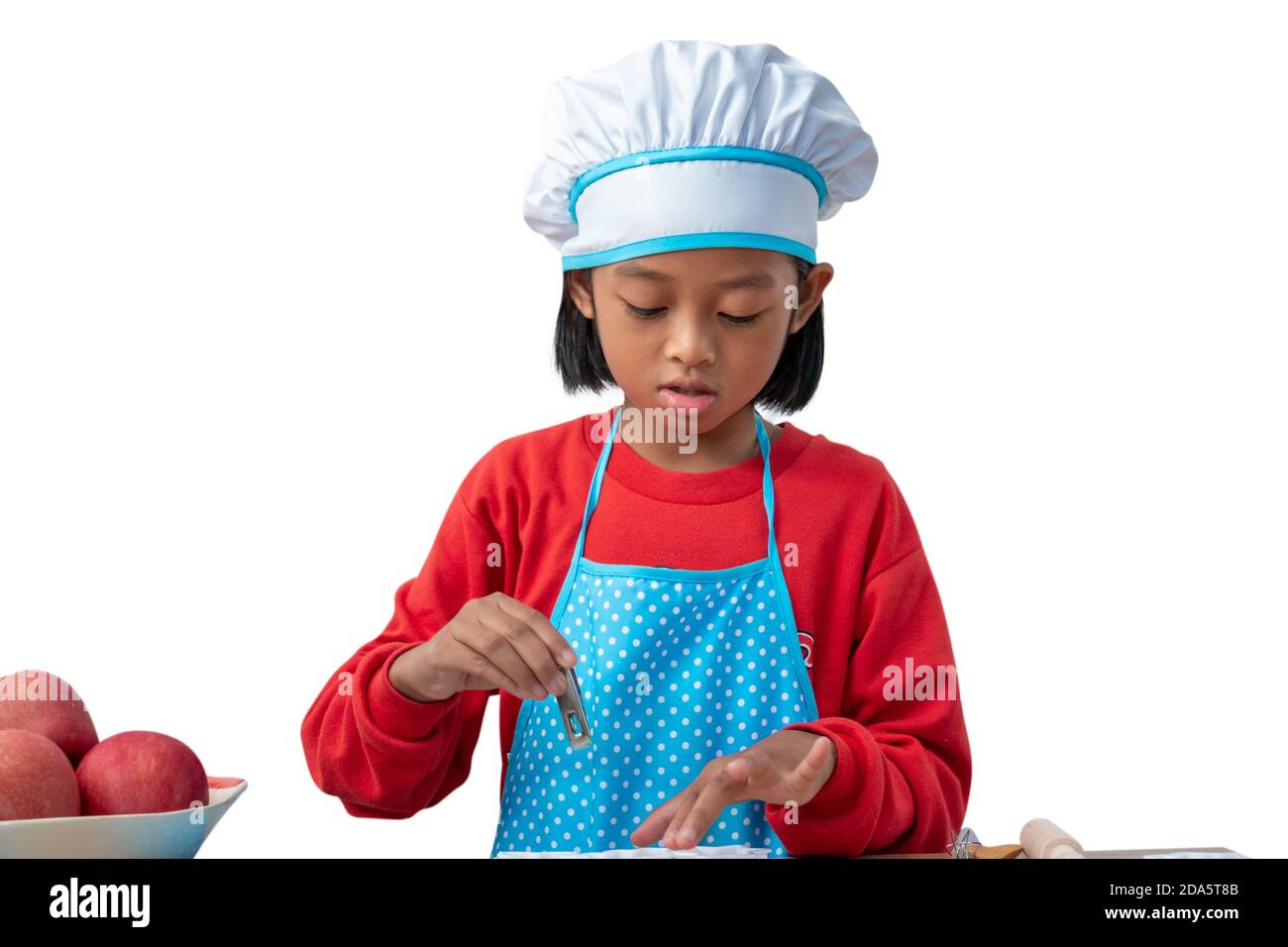 Cute girl in chef uniform and simulated cooking toys in the kitchen ...