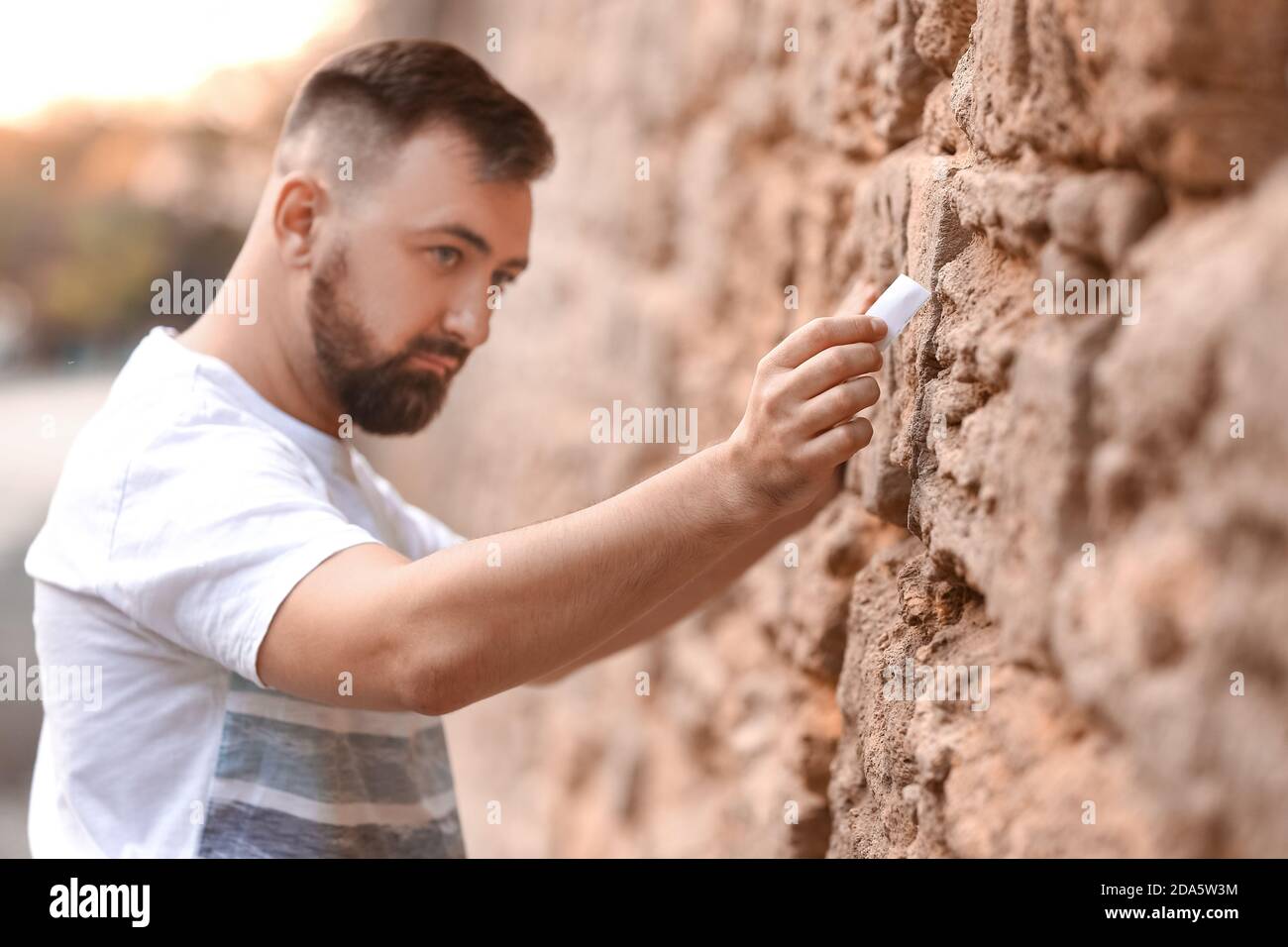 Man placing note in the Wailing Wall Stock Photo - Alamy