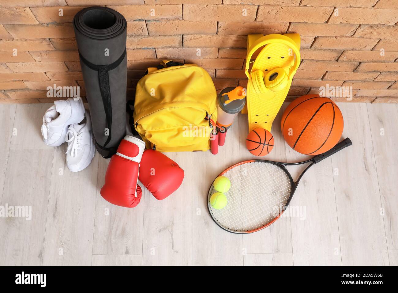 Set of sport equipment on floor near brick wall Stock Photo - Alamy