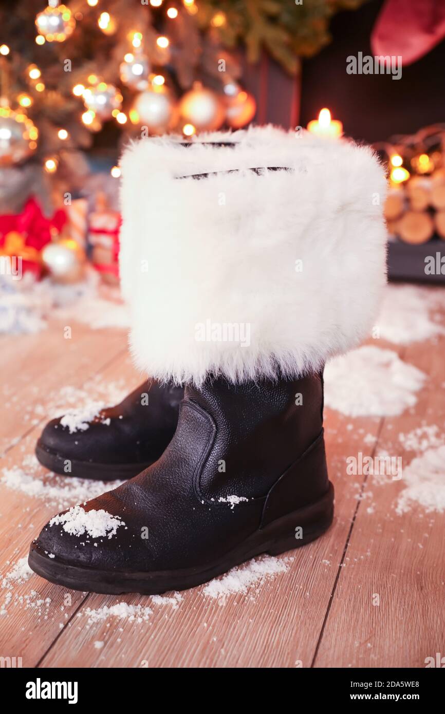 Boots of Santa and his footprints on floor in room decorated for ...