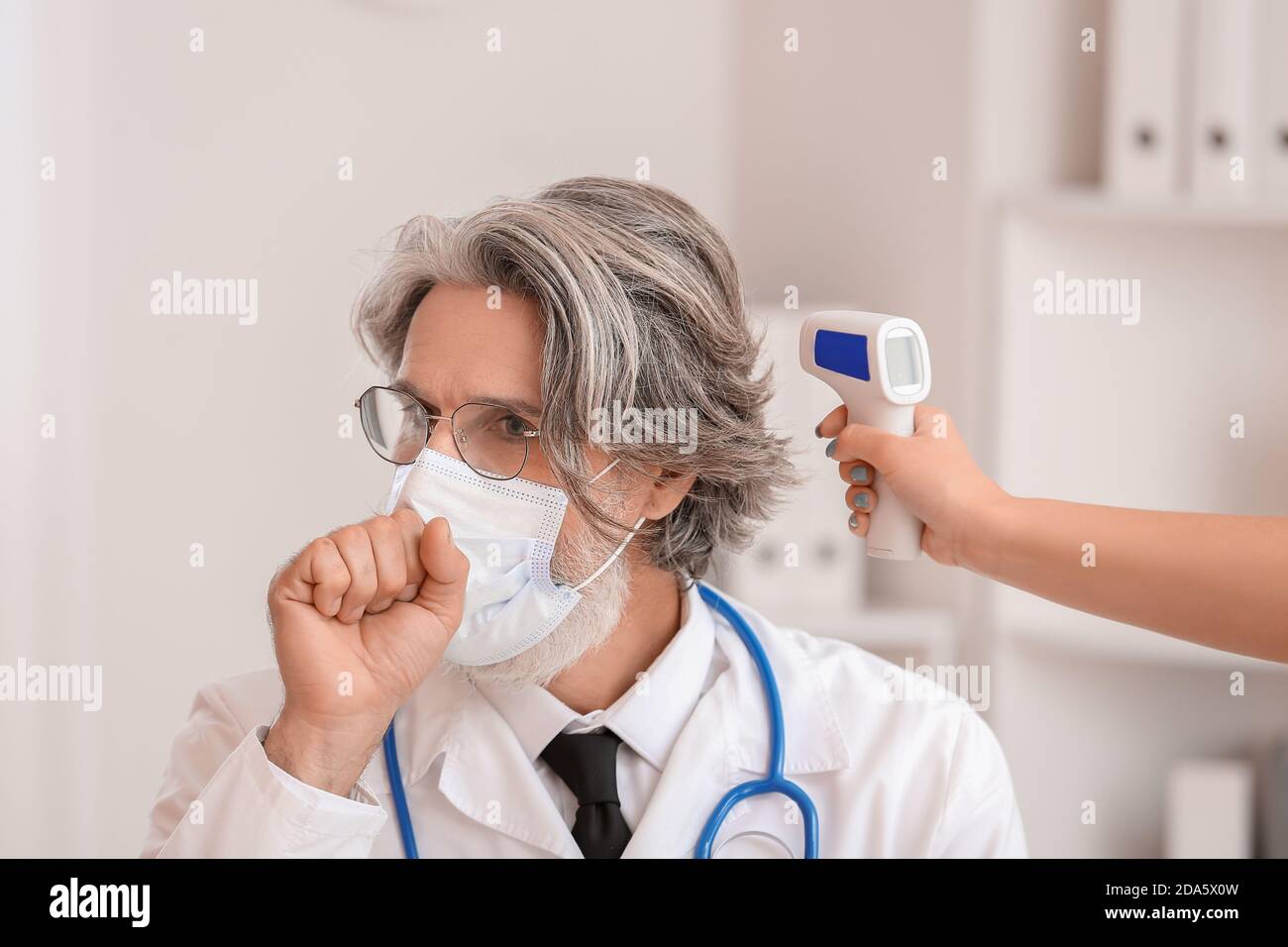 Measuring of ill doctor's temperature in clinic Stock Photo - Alamy