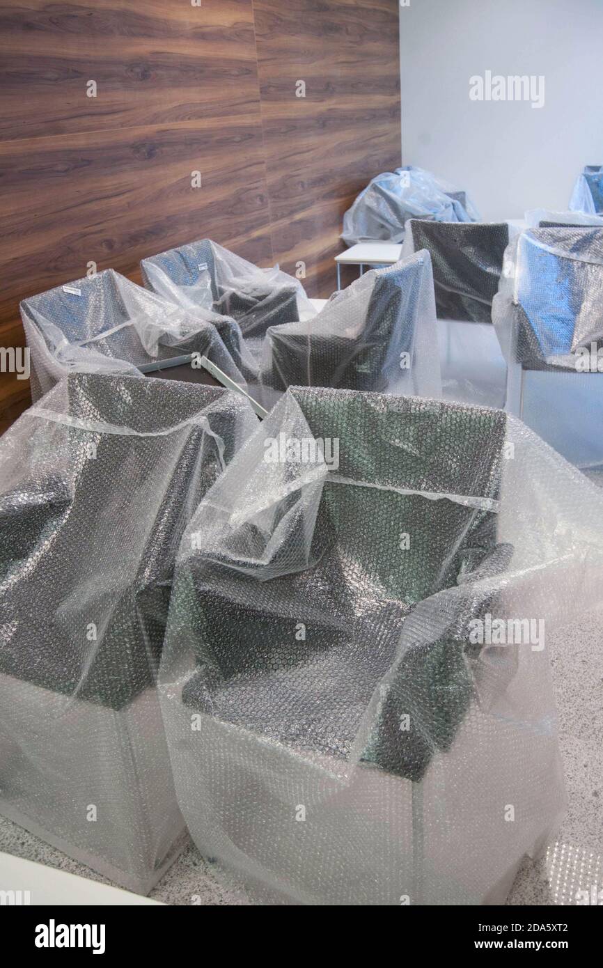 office chairs in bubble wrap, furniture for employees at the workplace ...
