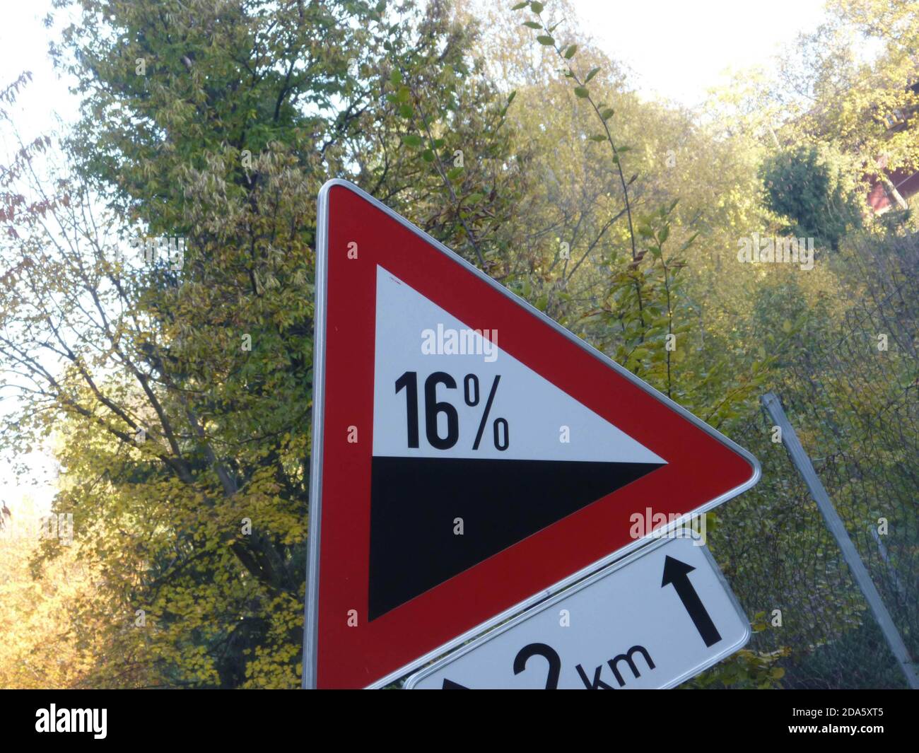 traffic sign gradient 16%, steep road ahead, red triangle, tree in ...