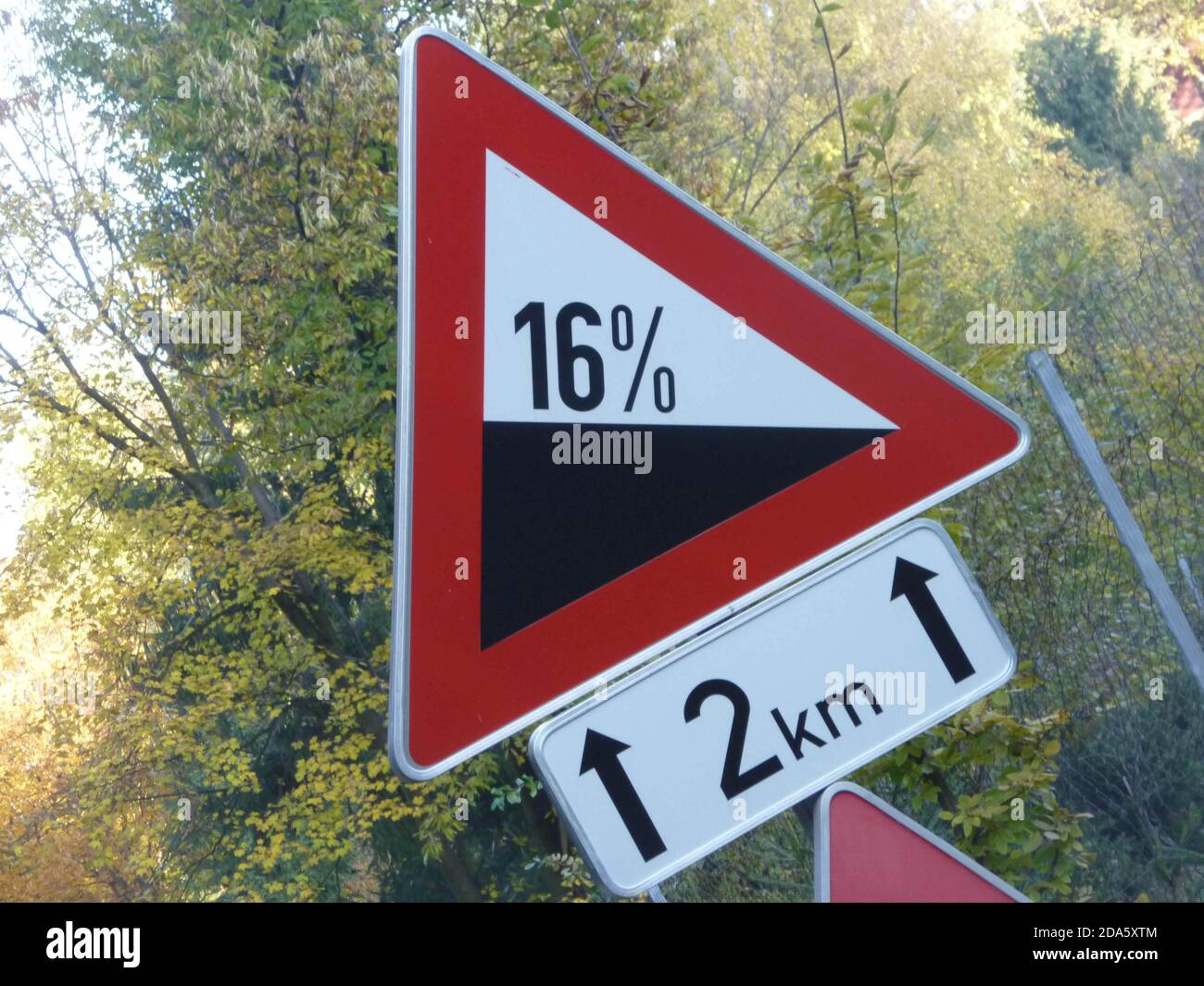 traffic sign gradient 16%, steep road ahead, red triangle, tree in ...