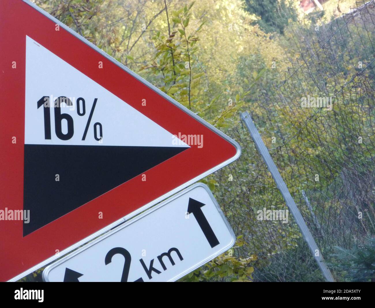 traffic sign gradient 16%, steep road ahead, red triangle, tree in ...
