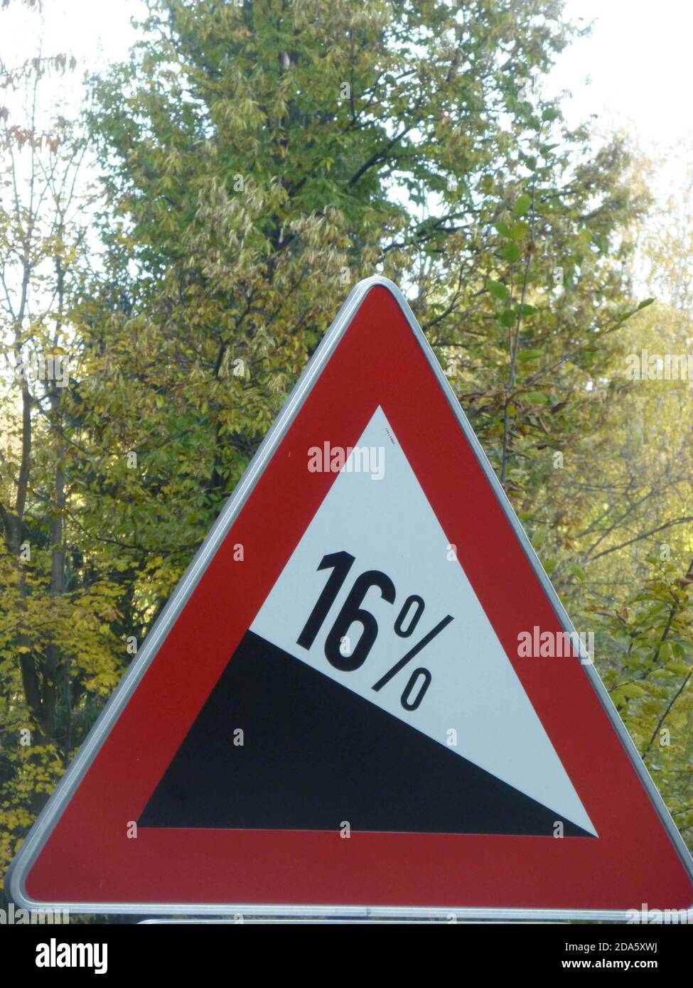 traffic sign gradient 16%, steep road ahead, red triangle, tree in ...