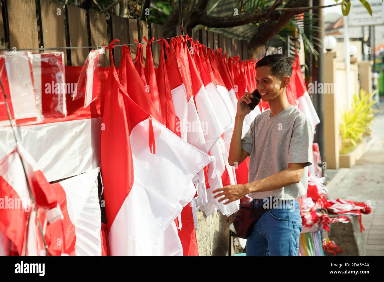portrait of a young man selling flags taking orders from a telephone ...