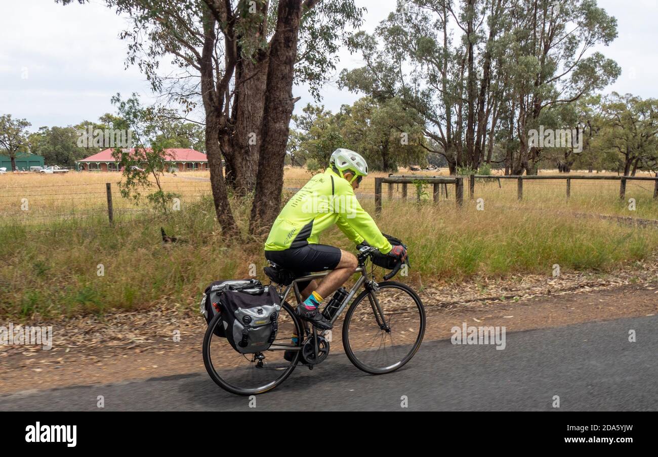 Touring cyclist travelling on vacation riding bicycle with panniers by ...