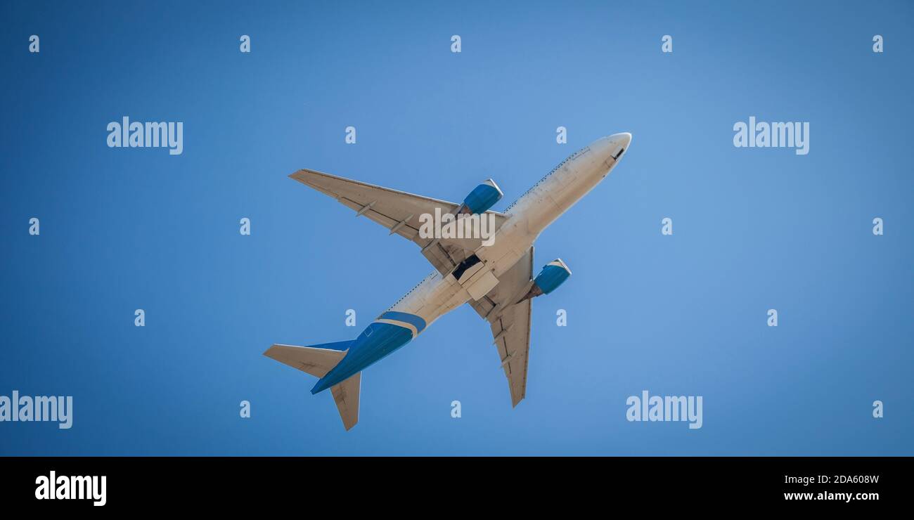 White plane flies in the sky. Bottom view. Takeoff and landing. Arrival ...