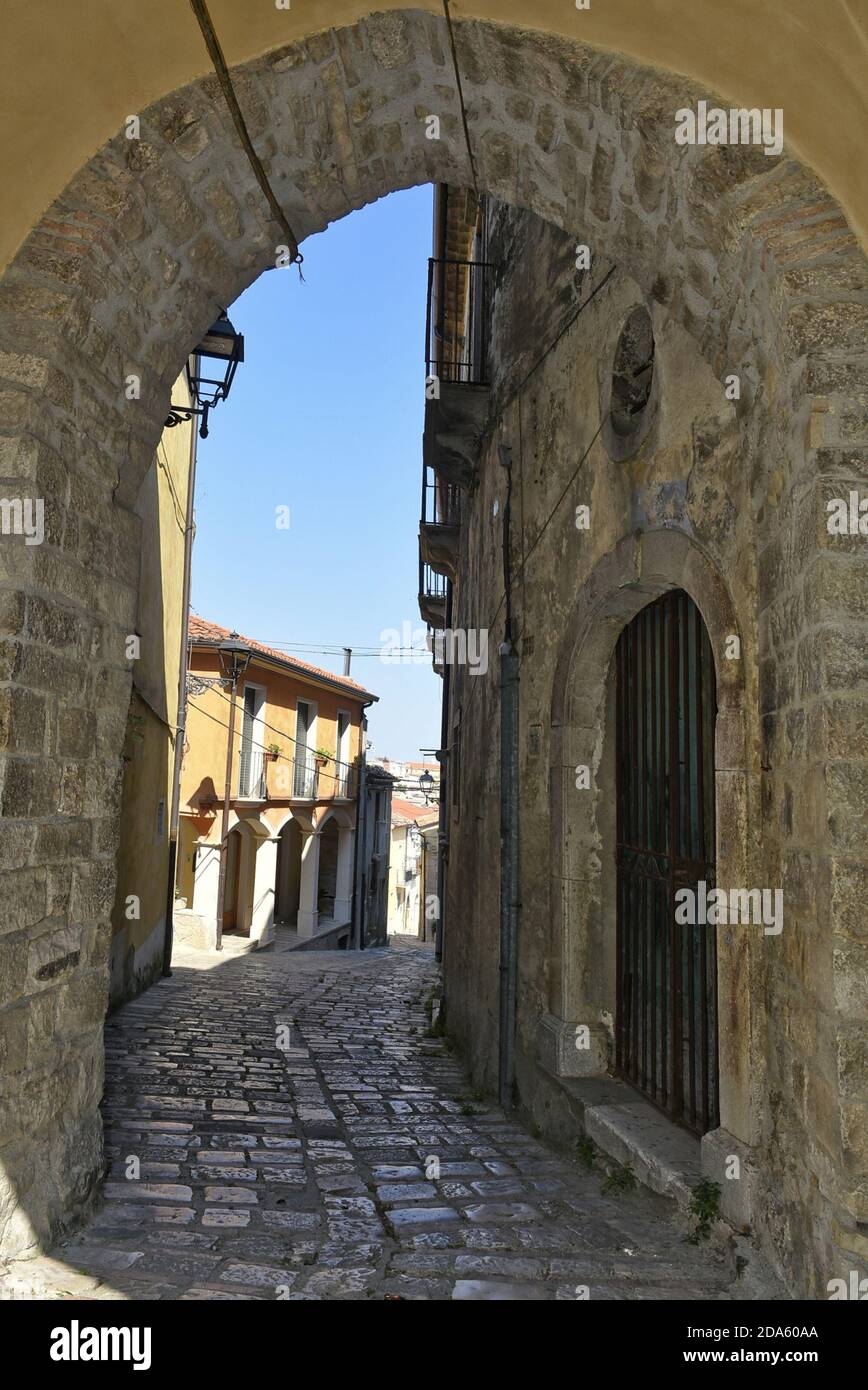 A narrow street among the old houses of Baselice, a rural village in ...