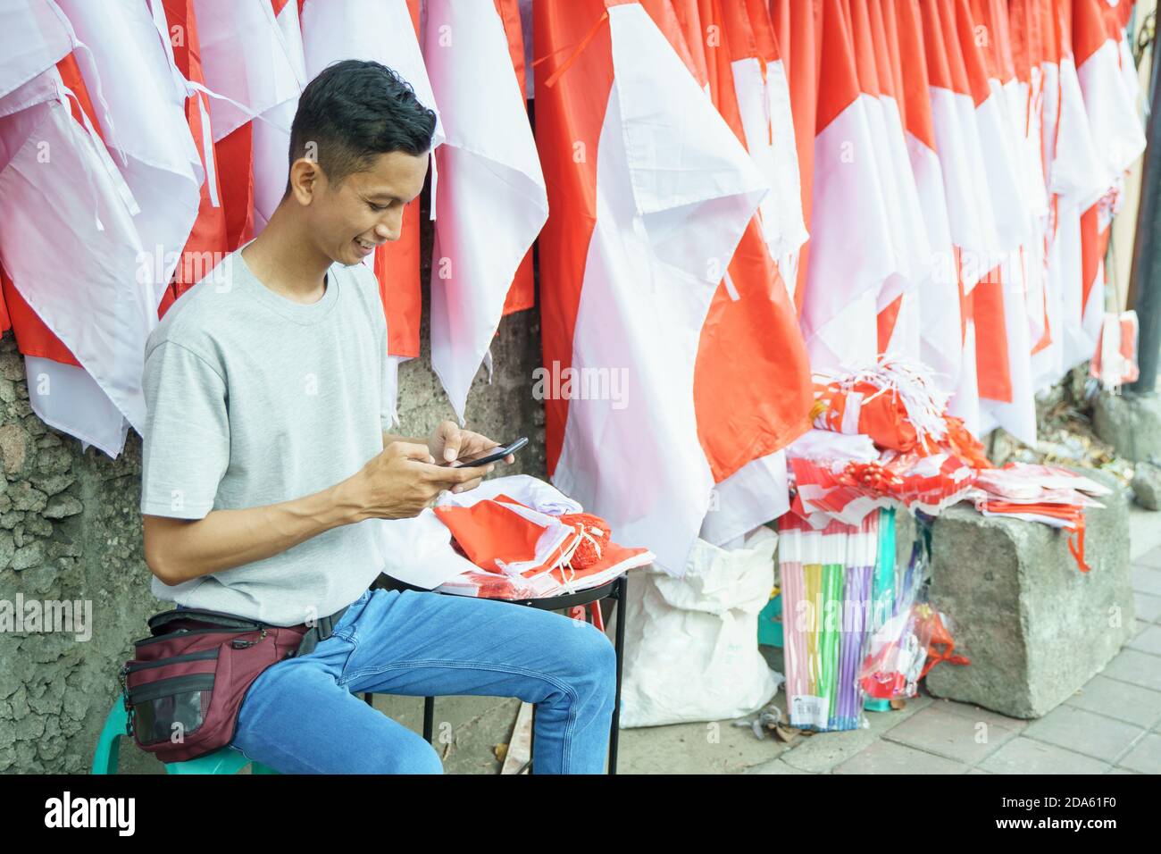 portrait of a young man selling flags taking orders from a telephone ...