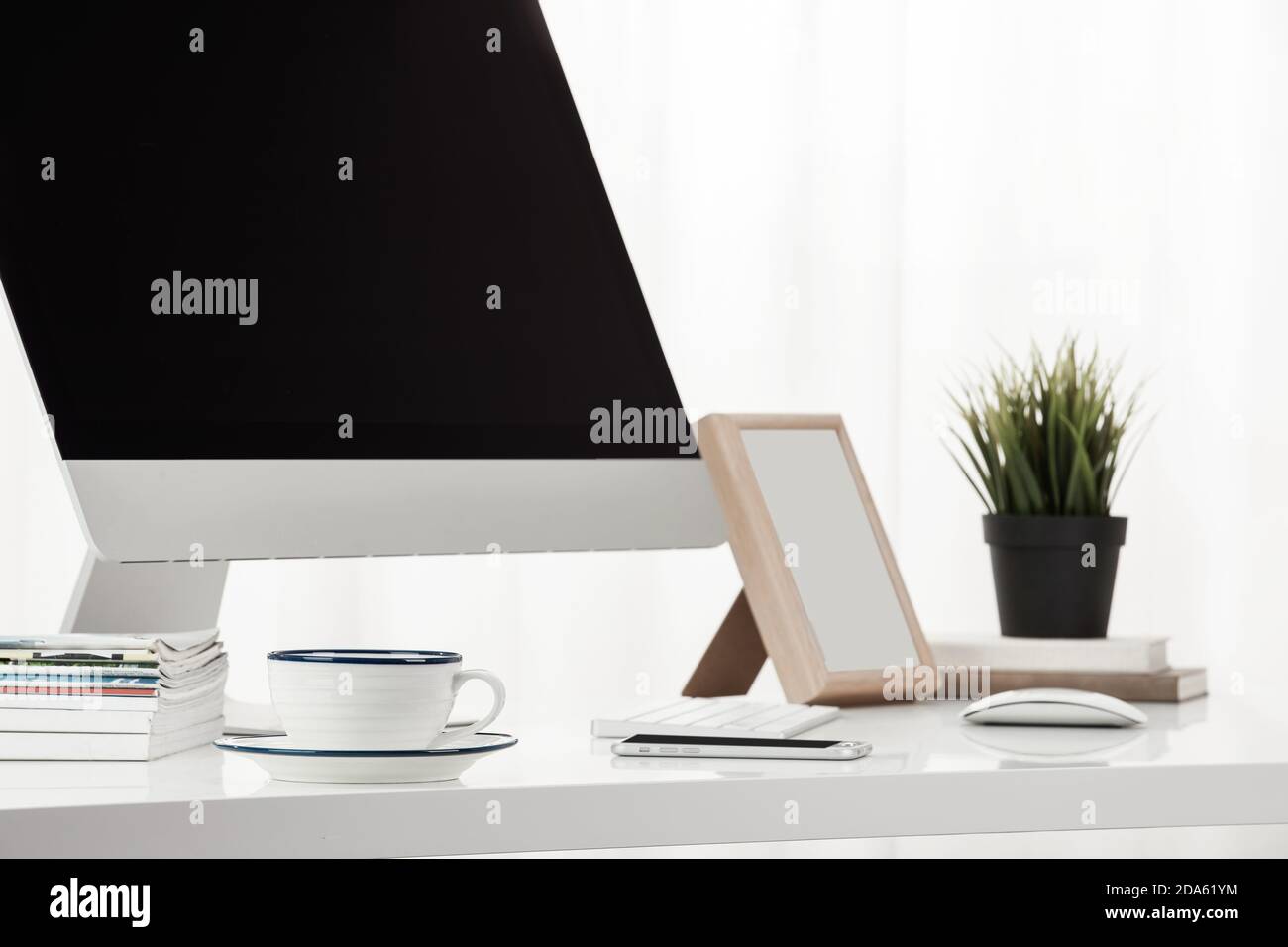 Closeup of a computer, a cup of coffee, books, magazines, and more on a ...