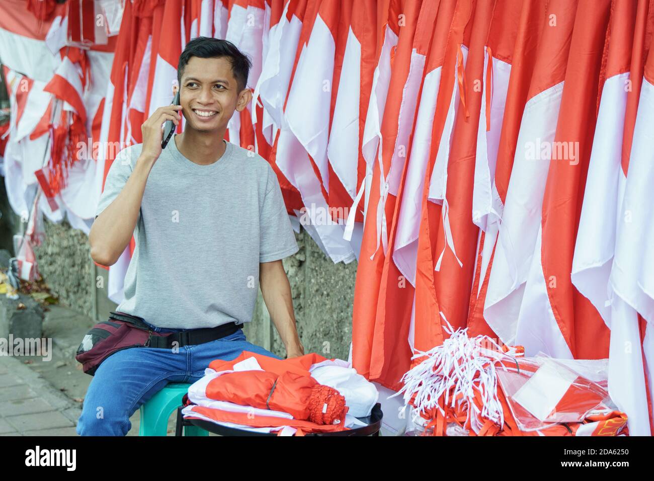 portrait of a young man selling flags taking orders from a telephone ...