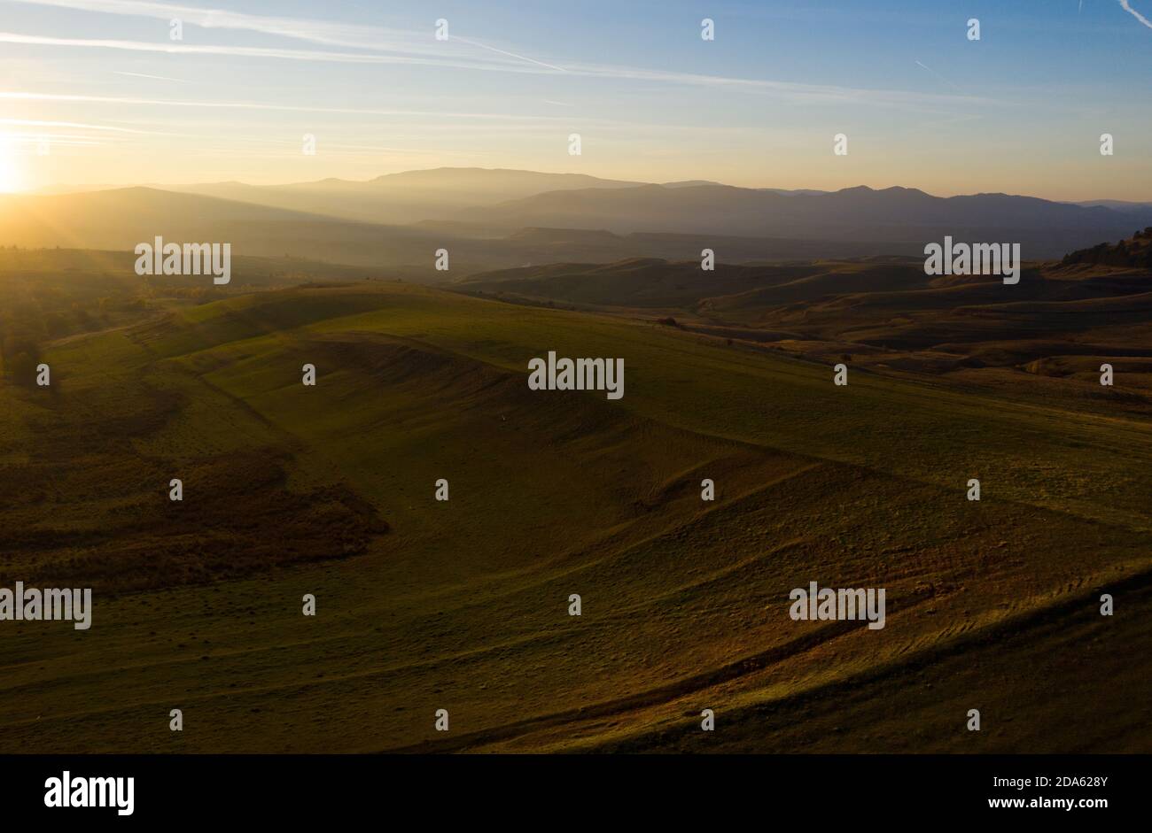 Aerial view of sunset above green hills by drone point of view Stock ...