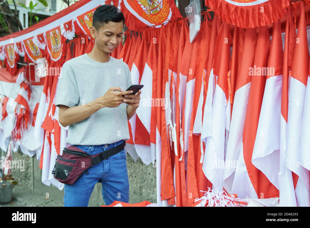 portrait of a young man selling flags taking orders from a telephone ...