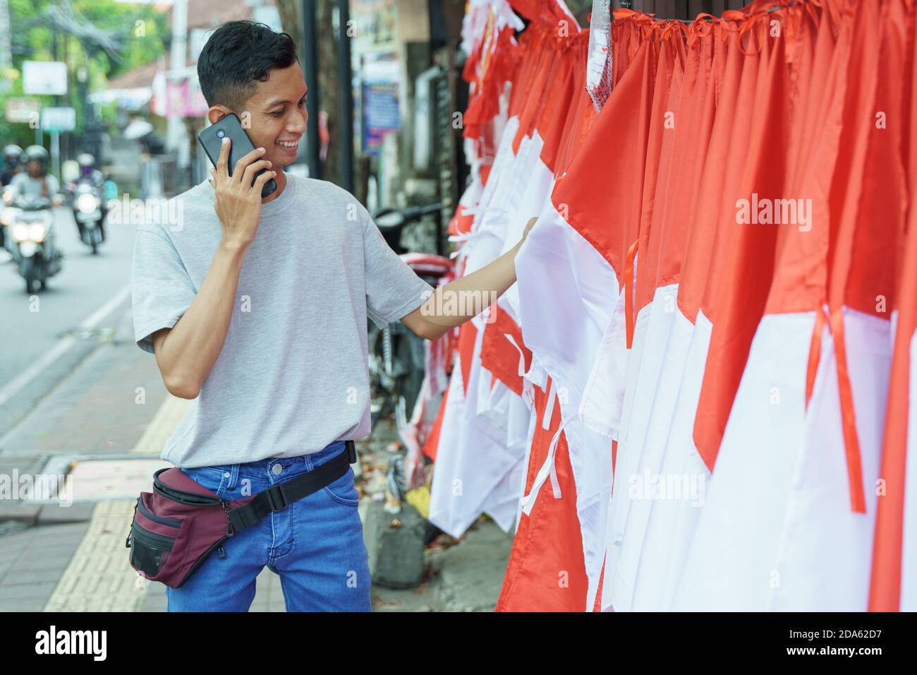 portrait of a young man selling flags taking orders from a telephone ...