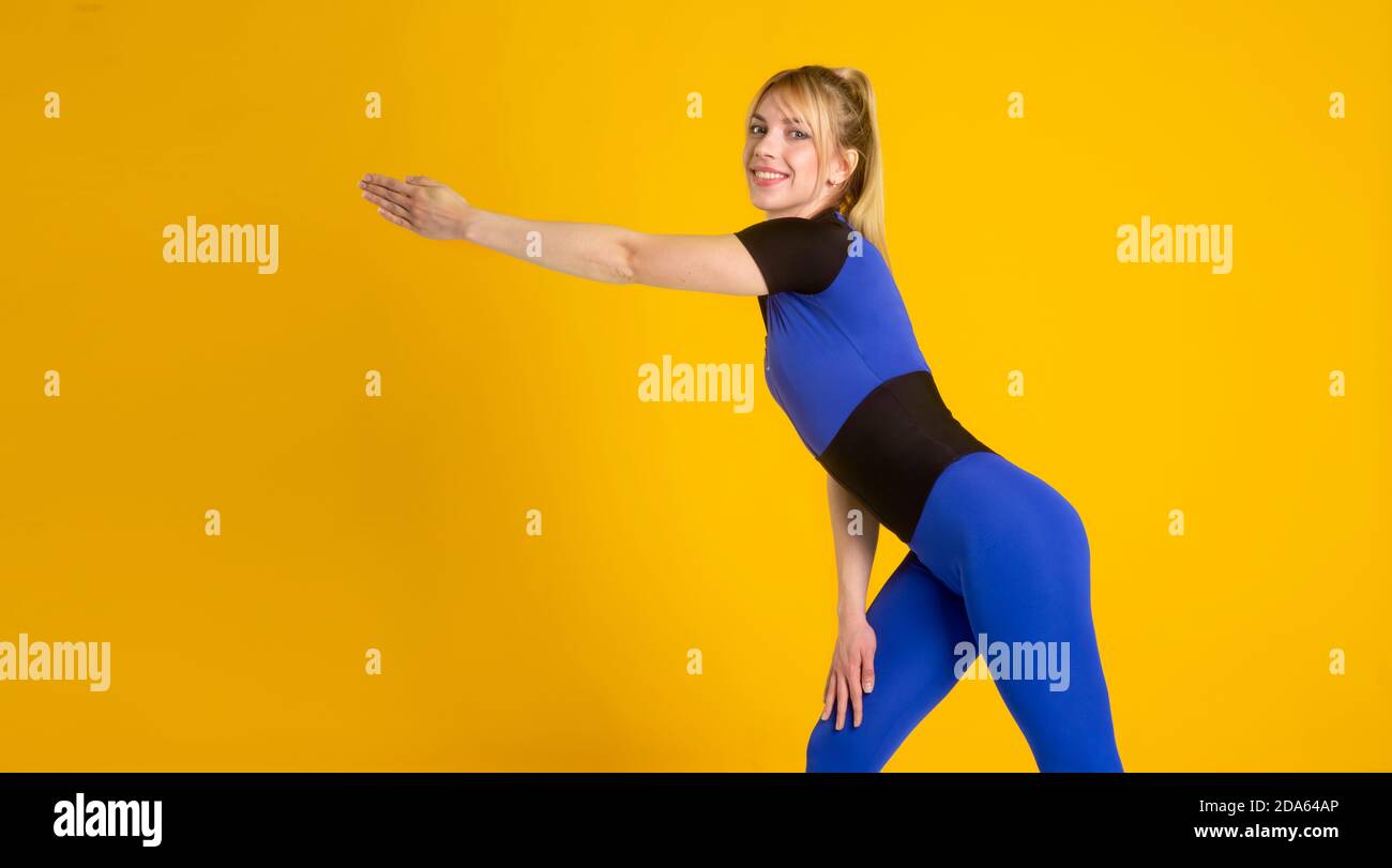 Young woman in sports clothes doing side bends on white isolated ...