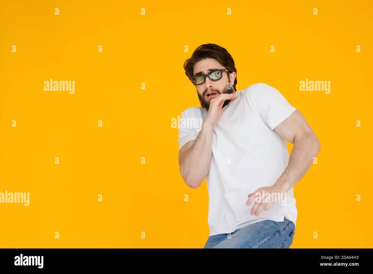 Portrait of a shaggy, bearded scared man in 3D glasses with an open ...