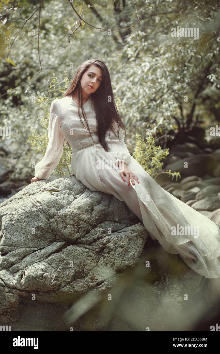 Beautiful romantic girl posing on a rock Stock Photo - Alamy