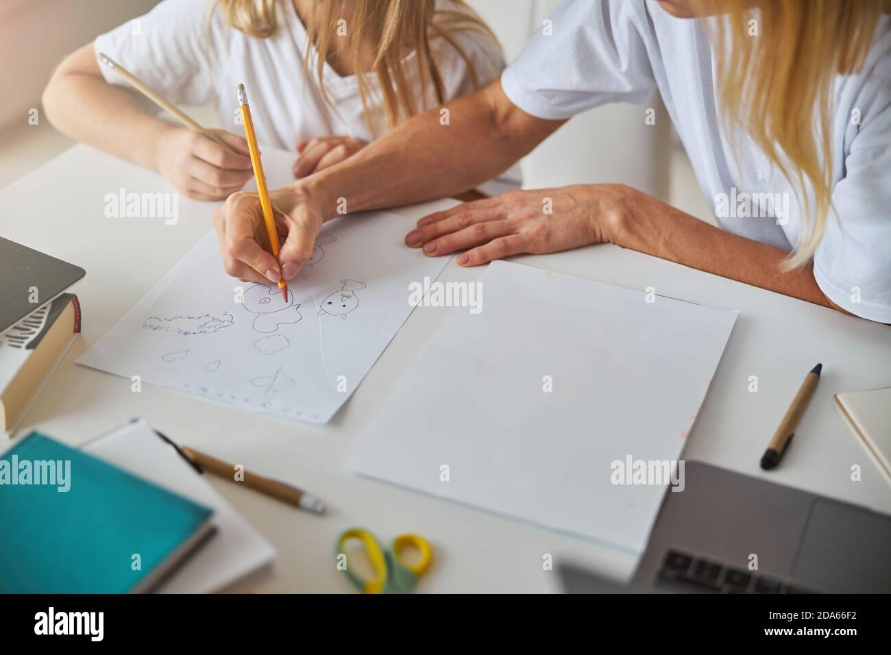 Adult smart mother showing rules in art while little girl sitting hear ...