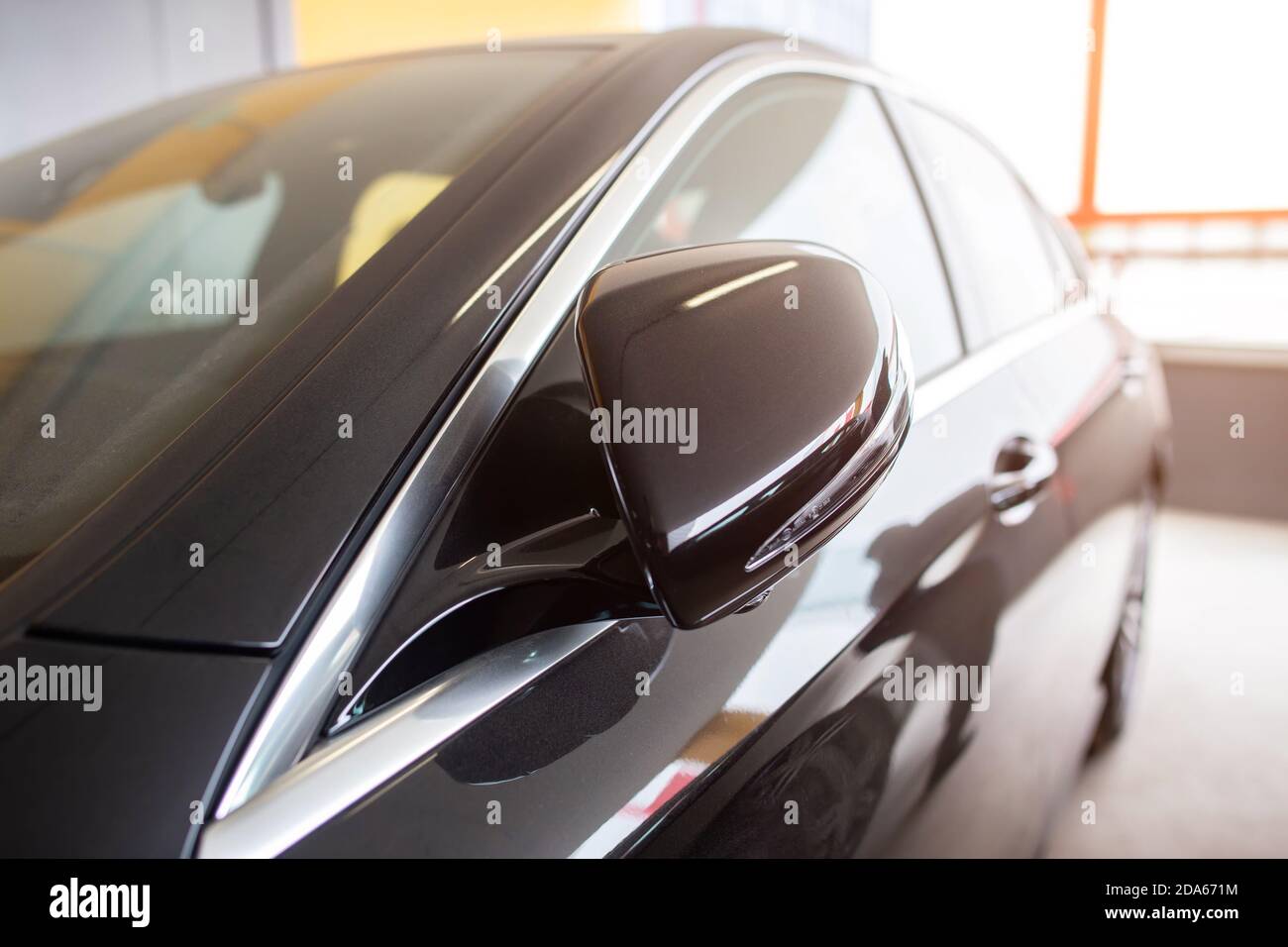 Modern folding mirrors with turn signal in a black new car, outdoor ...