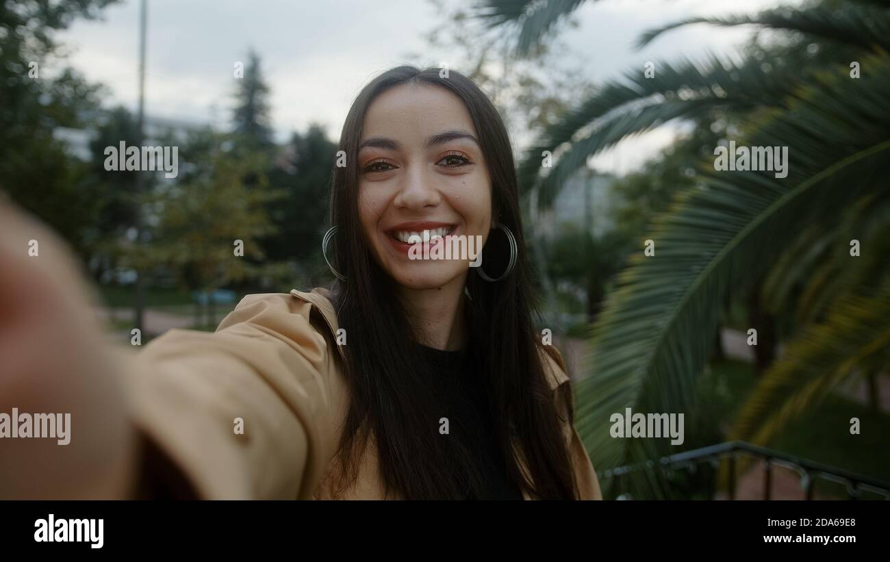 Beautiful young smiling face woman holding camera or phone in hand and ...
