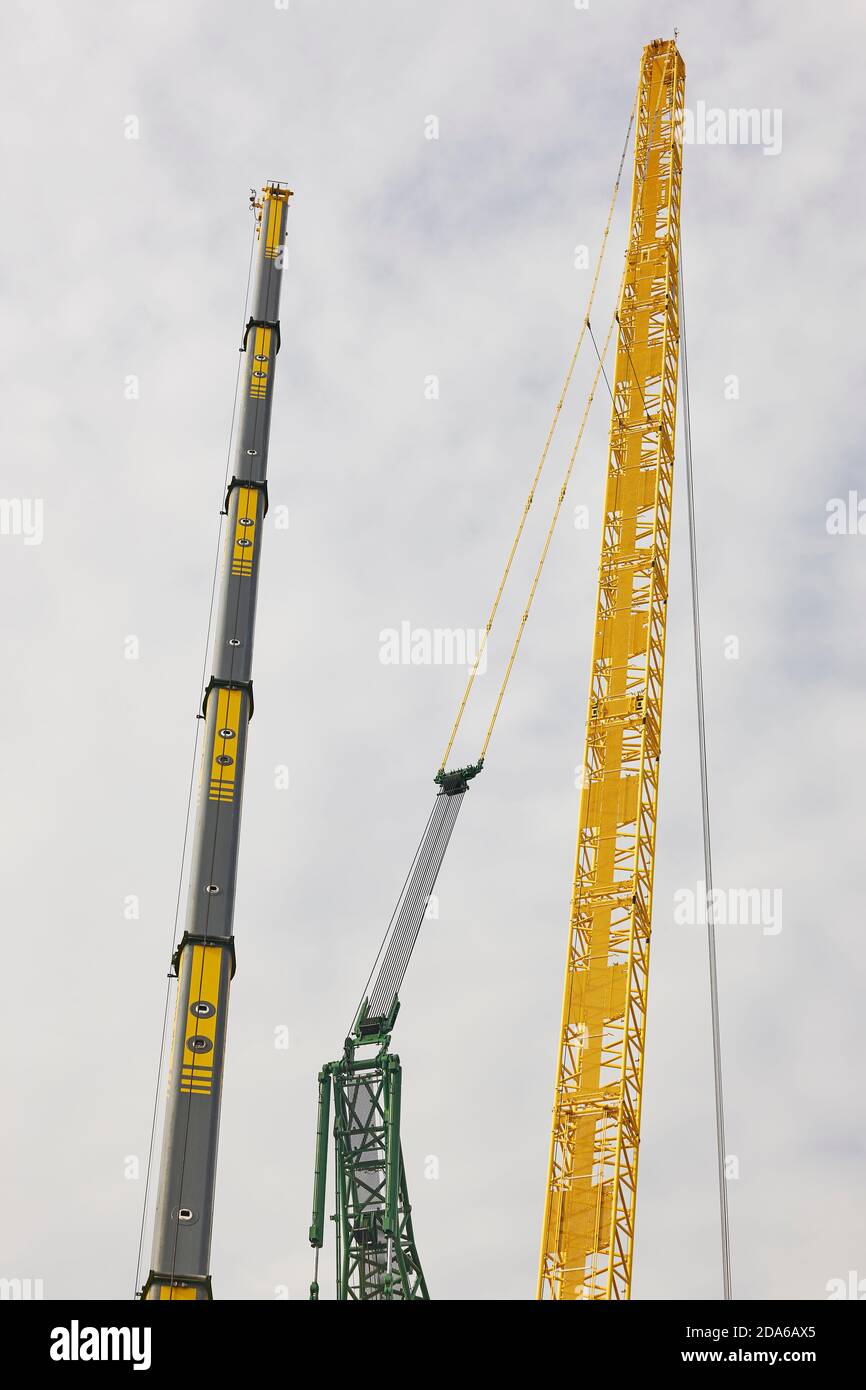 Telescopic cranes under a white sky. Construction engineering industry ...