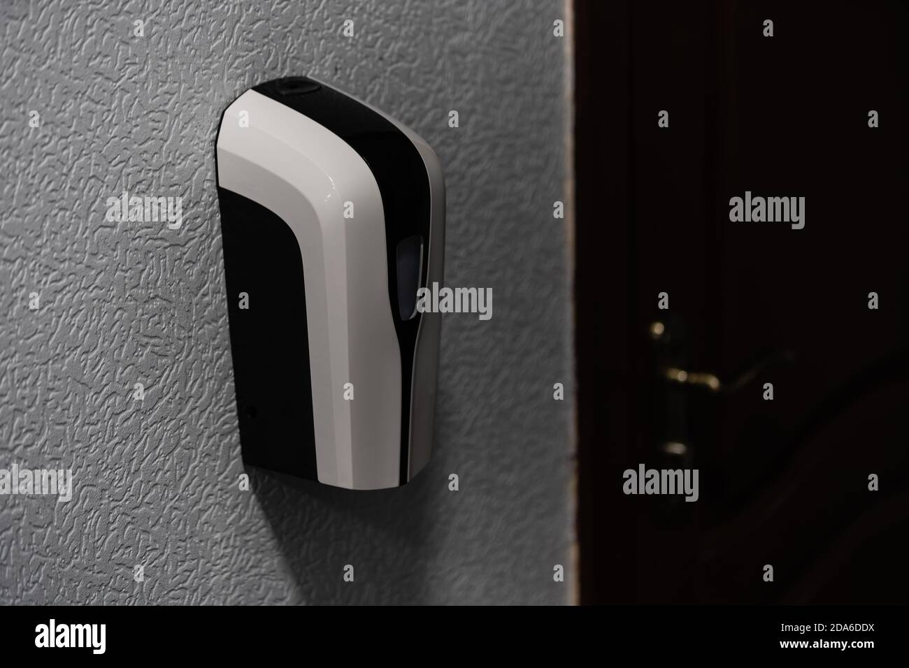 Modern motion sensor on wall indoors Stock Photo - Alamy