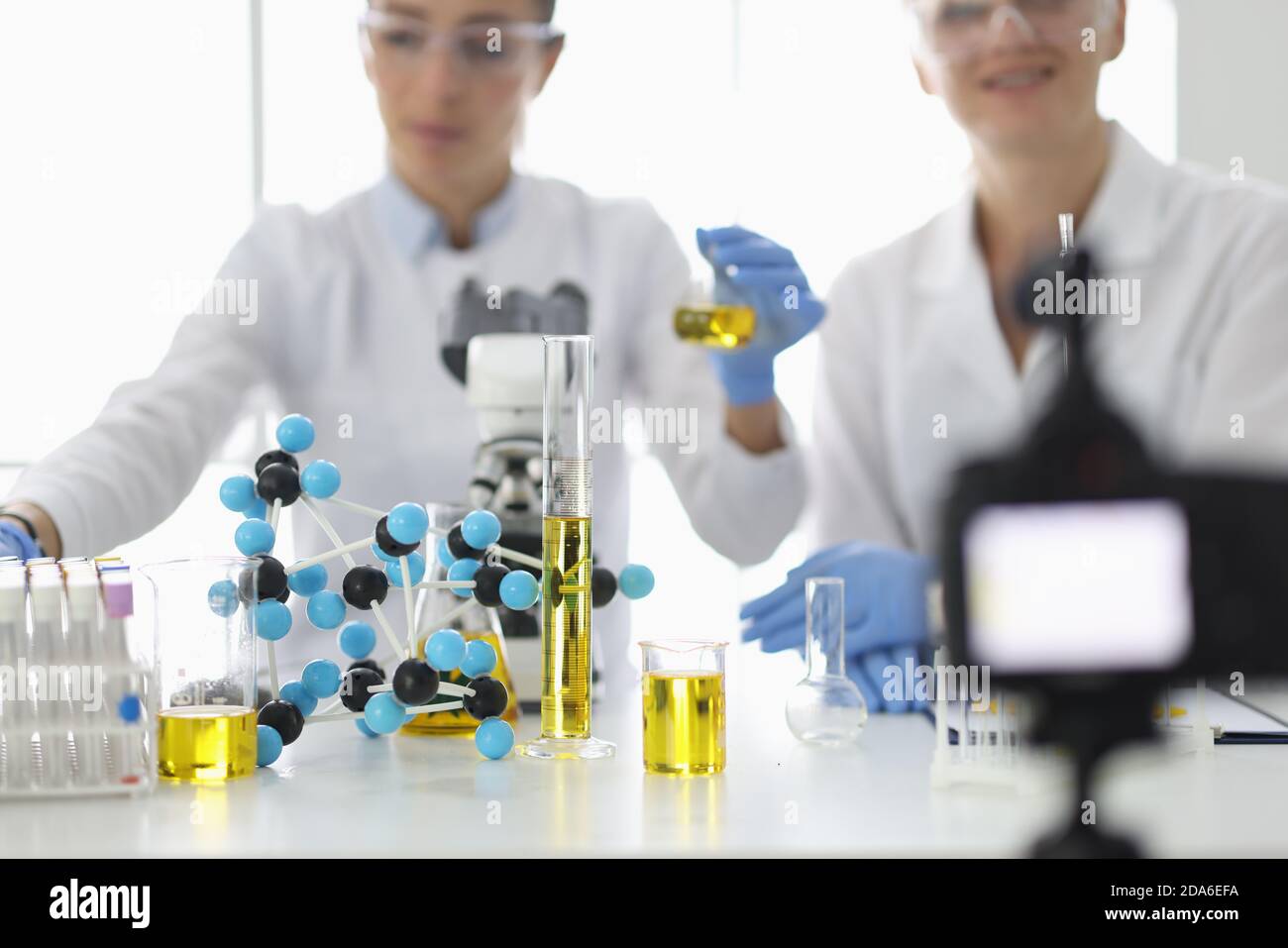 Scientists at work table on which flasks and molecules are filming ...