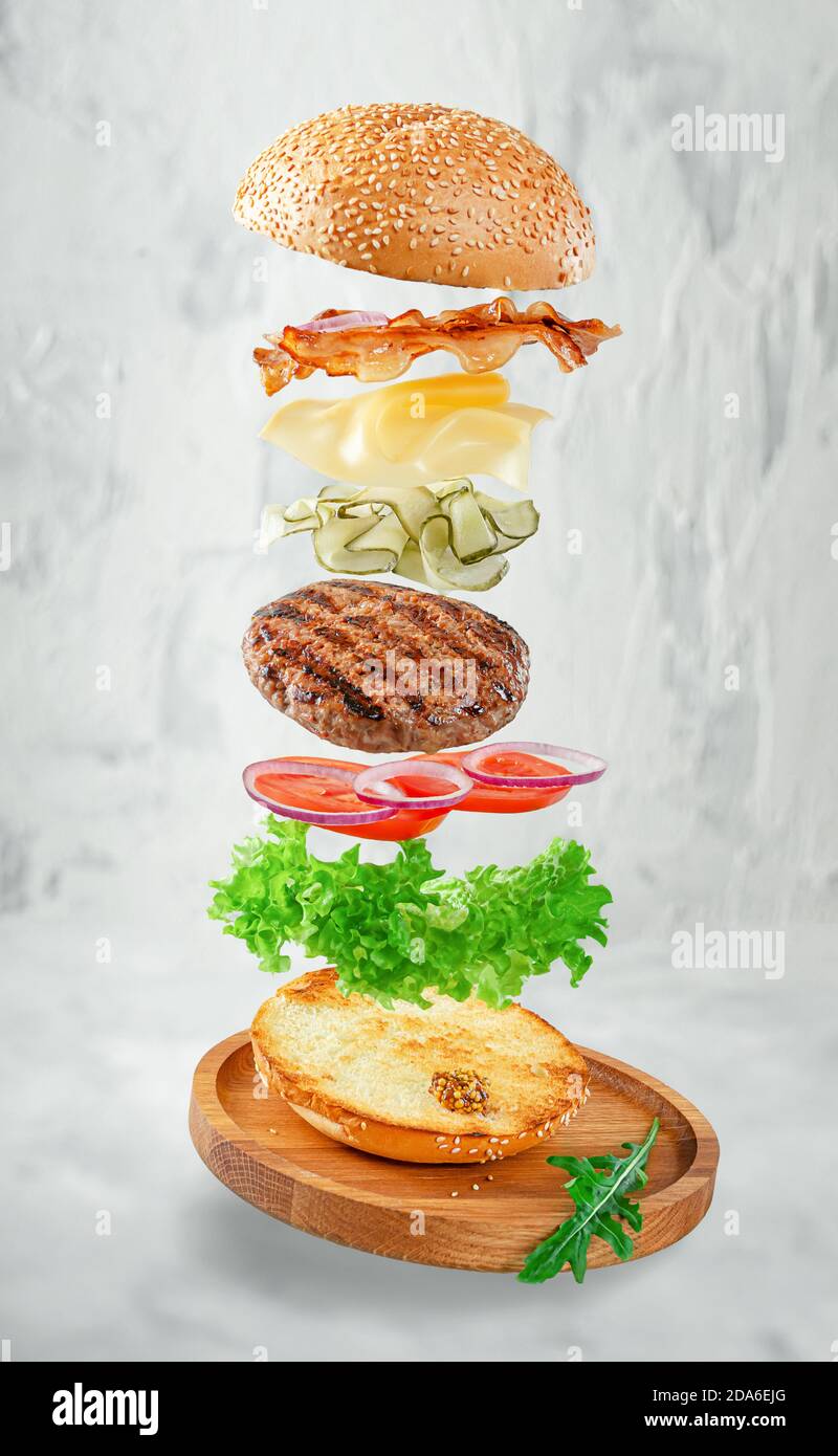 Flying hamburger on gray concrete background. Fast food concept Stock ...