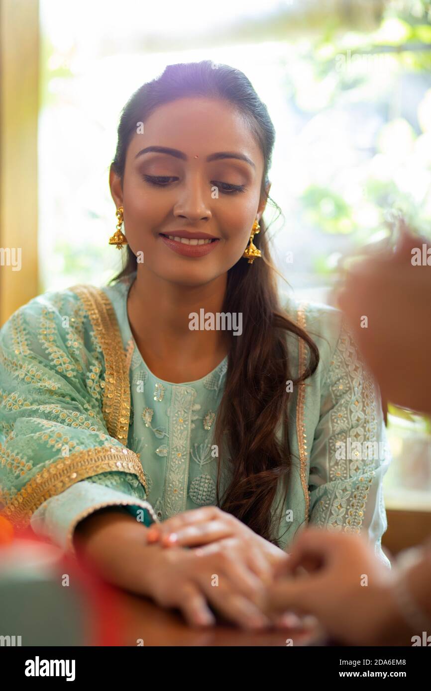 Young woman looking down at her hand Stock Photo - Alamy