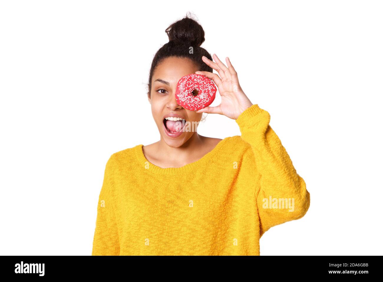Close up portrait of cheerful young woman looking through a donut and ...