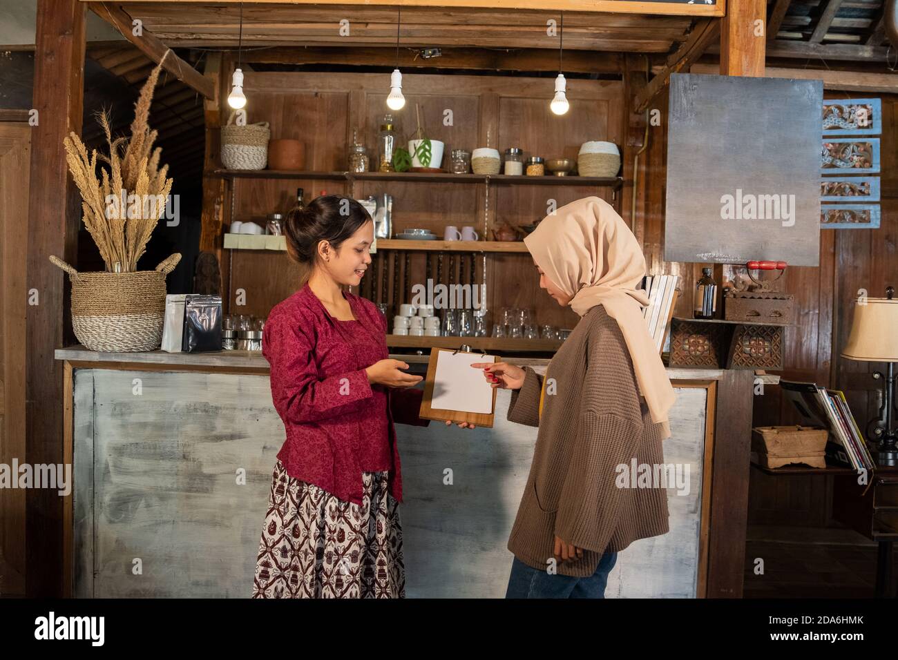 waiters shows the menu to the customer at traditional javanese shop ...
