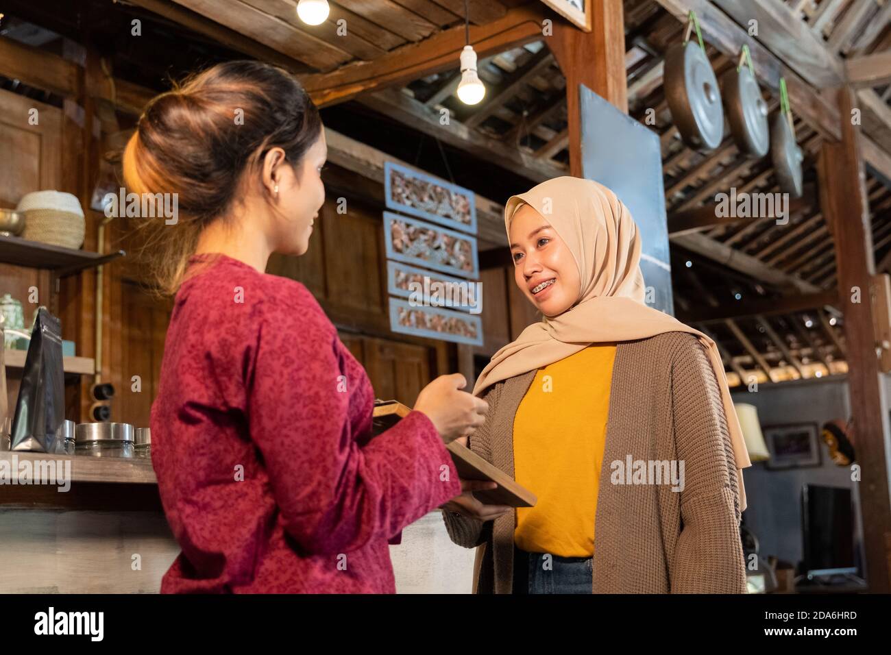 waiters shows the menu to the customer at traditional javanese shop ...