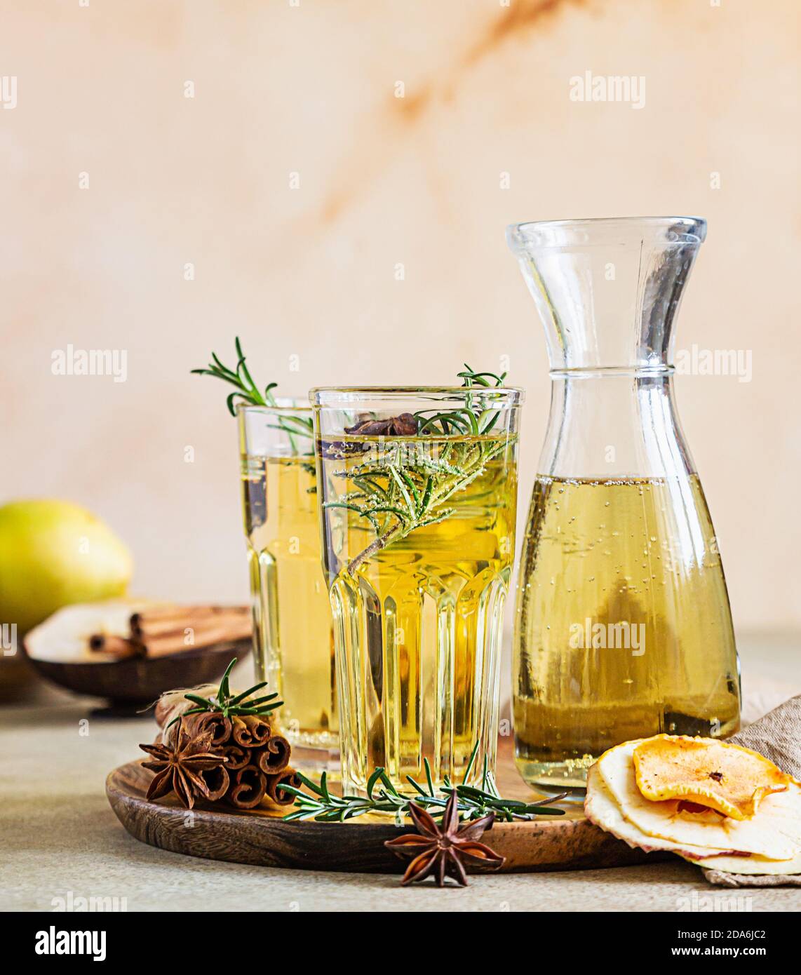 Pear or apple cider in glasses and bottle with rosemary, cinnamon and ...
