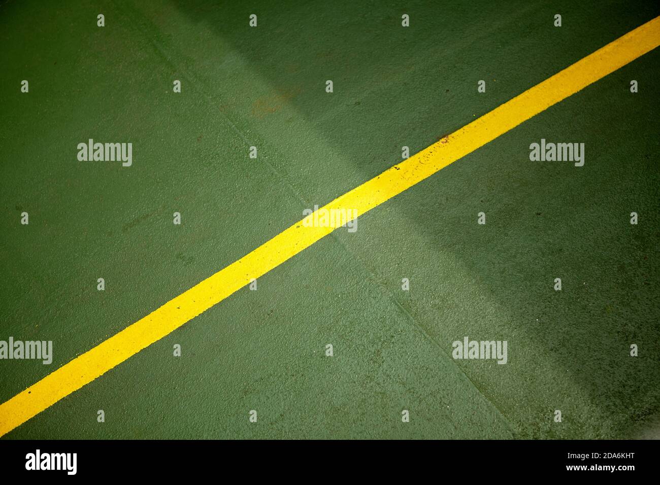 Bold yellow safety line on a green ferry floor Stock Photo - Alamy