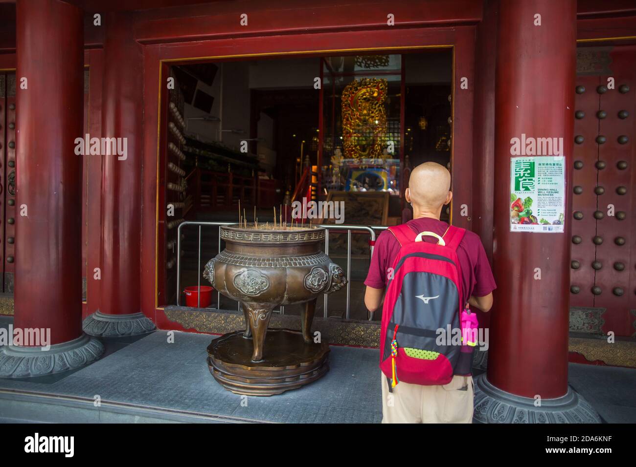Back view of a bald senior praying sincerely in-front of the buddhism ...