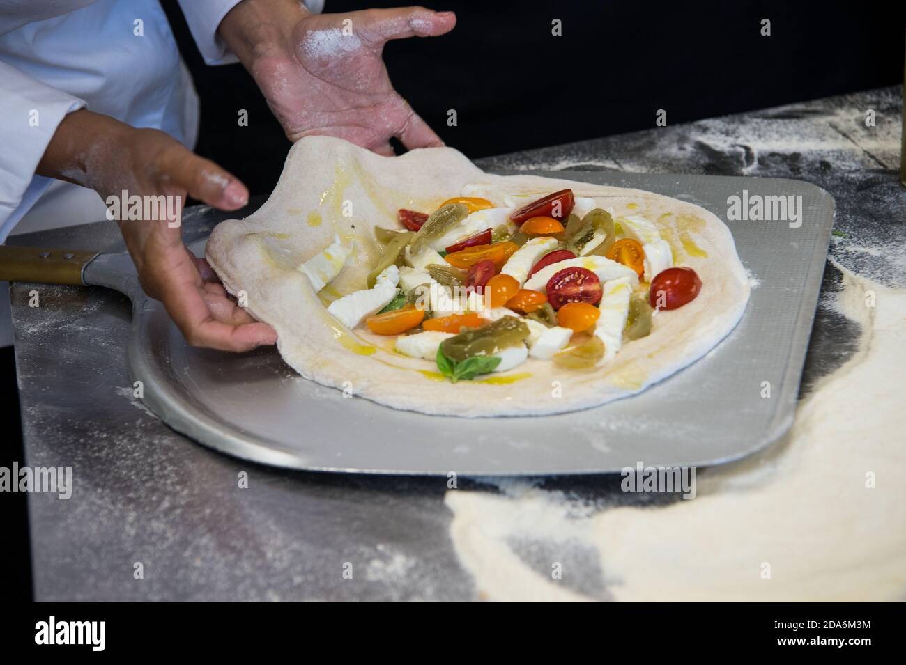 detail of the hands of a pizza chef chef who works for the various ...