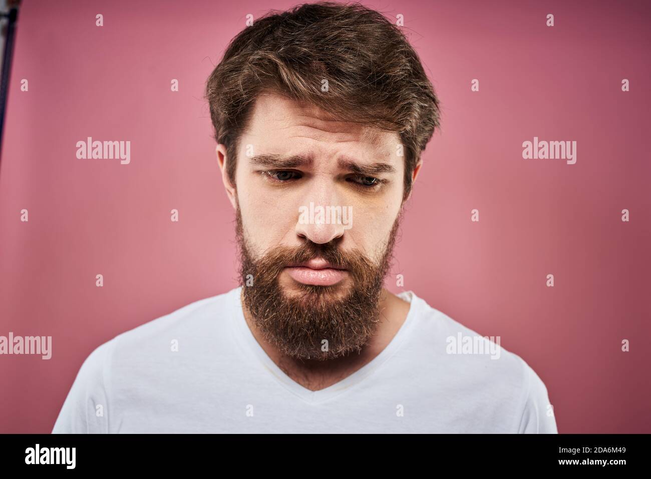 bearded man in white t-shirt emotions displeased facial expression ...